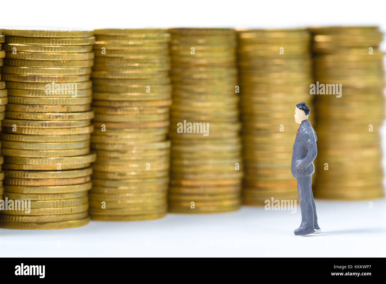Figure miniature businessman or small people standing with stack of ...
