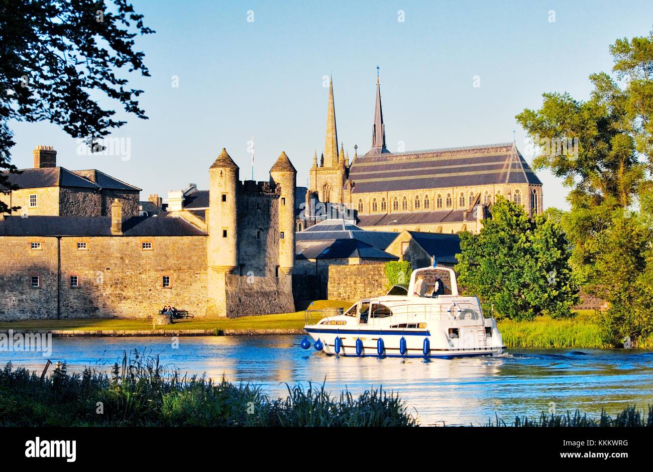 Pleasure boat on River Erne waterway passing Enniskillen Castle and St ...