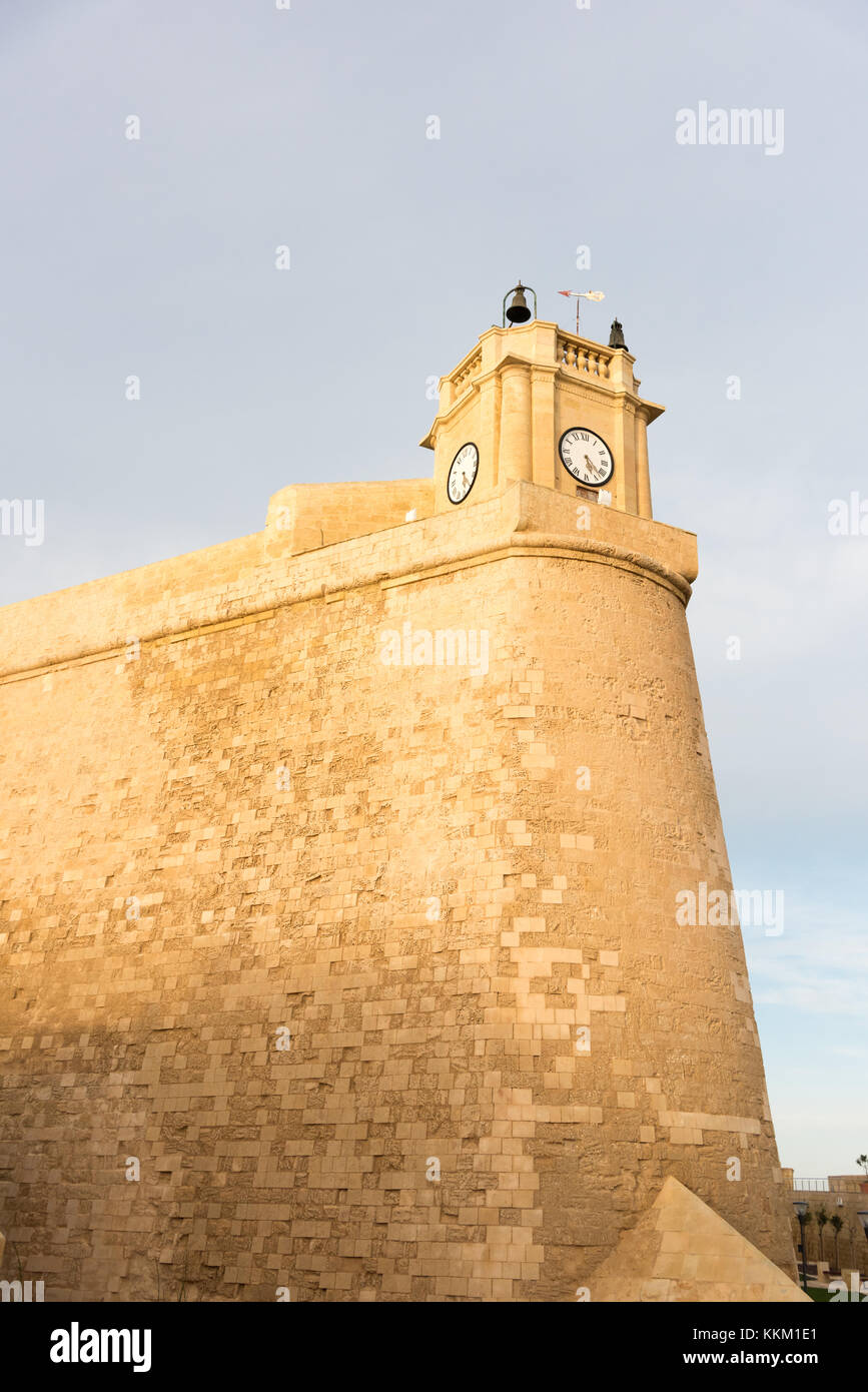 An ancient stone city wall with a clock tower in Gozo Malta Europe ...