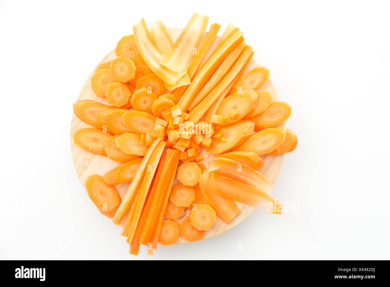 Sliced carrots on round wooden plate, on white background Stock Photo ...