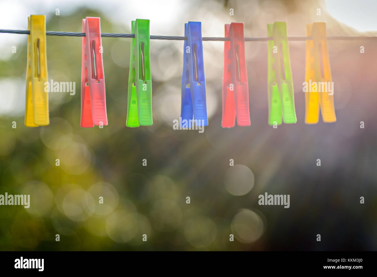 Colorful pegs hanging on clothesline Stock Photo - Alamy