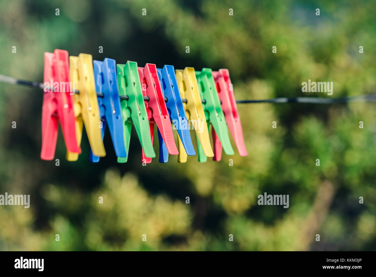 Colorful pegs hanging on clothesline Stock Photo - Alamy