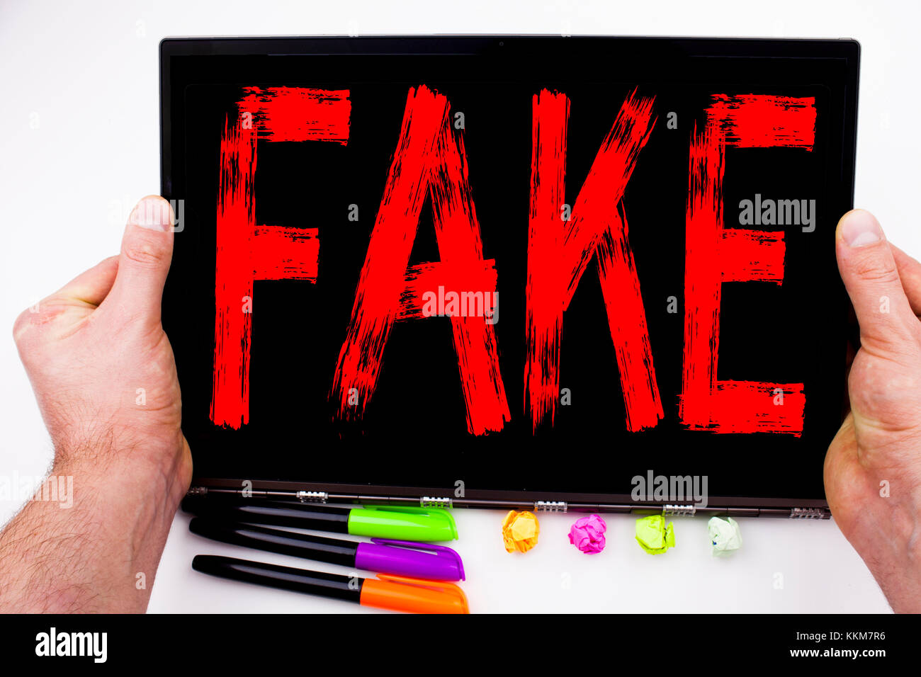 Fake News text written on tablet, computer in the office with marker ...