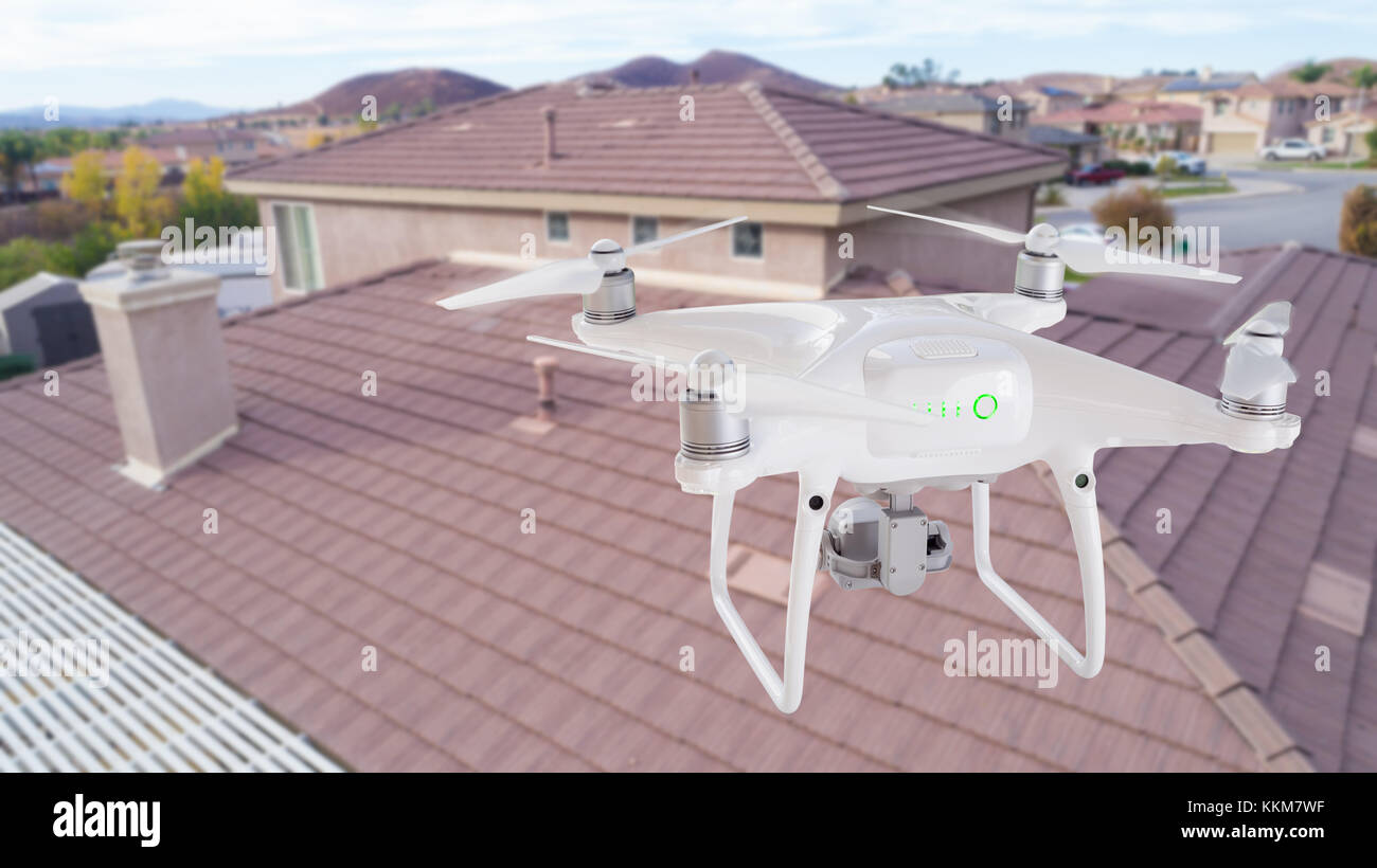 Unmanned Aircraft System (UAV) Quadcopter Drone In The Air Over House ...