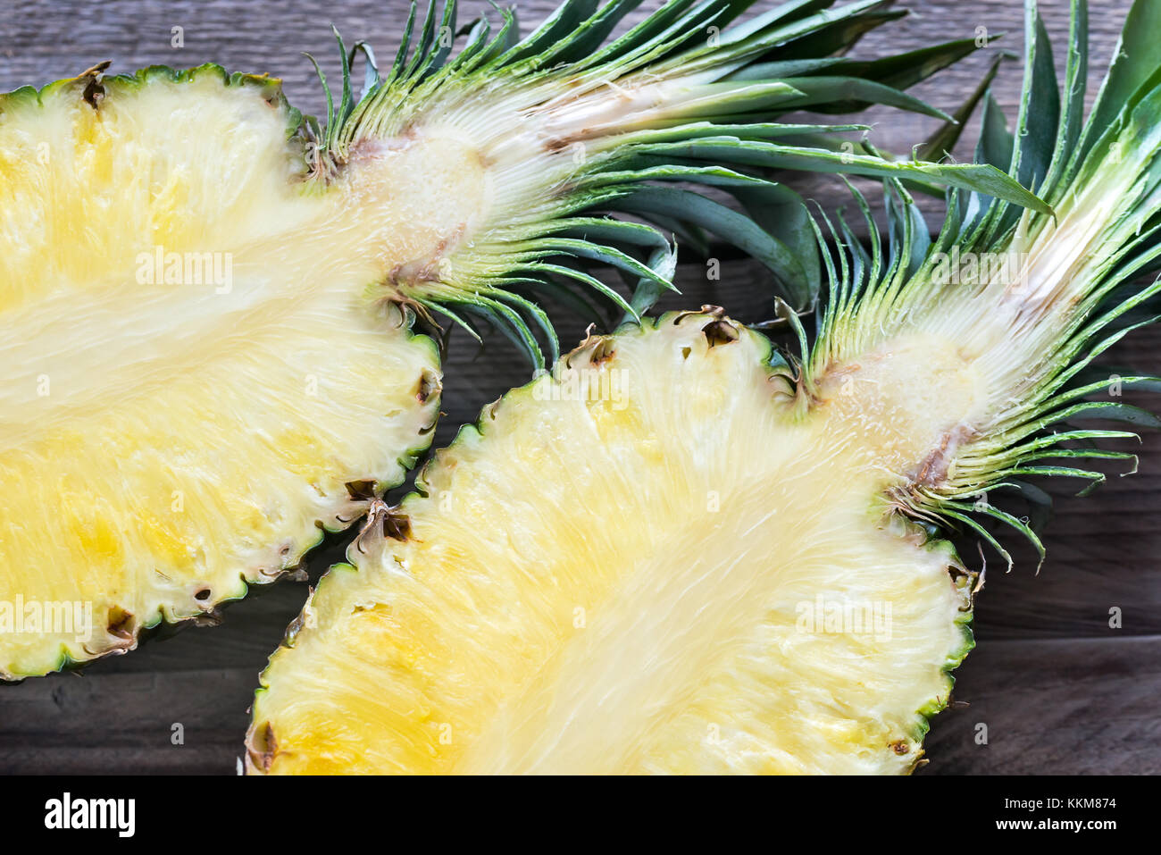 Pineapple on the wooden background: cross section Stock Photo - Alamy
