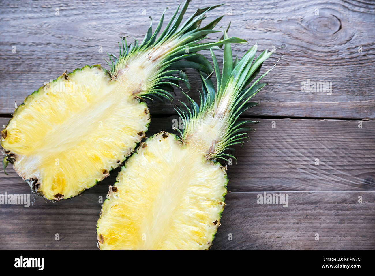 Pineapple on the wooden background: cross section Stock Photo - Alamy