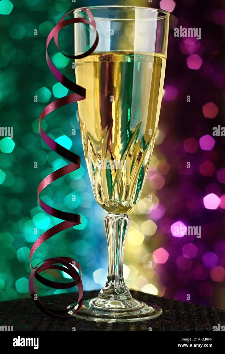 New Year's with glass of sparkling champagne and streamers on the table ...