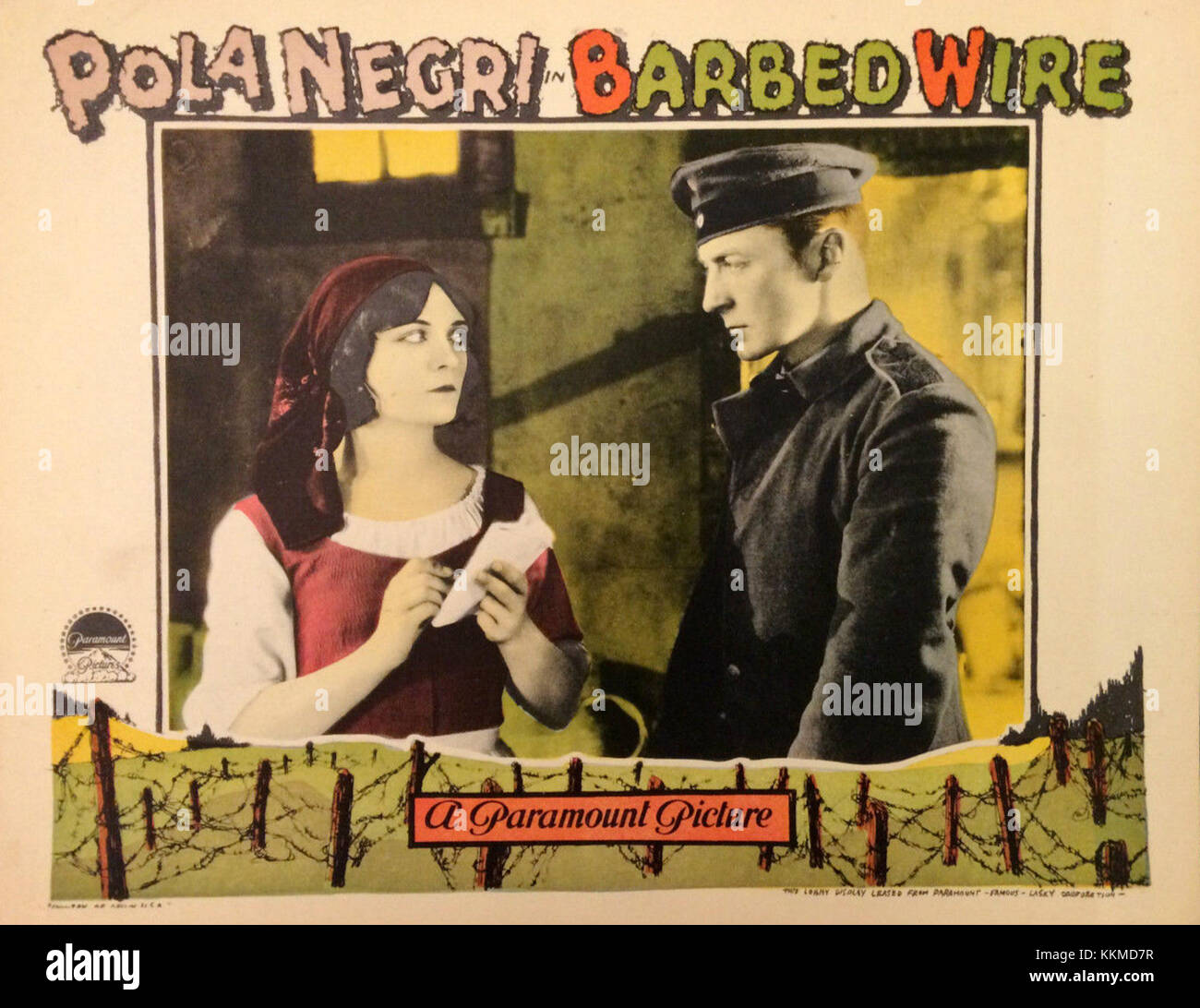 The lobby card depicts an image from the film *Barbed Wire*, capturing ...