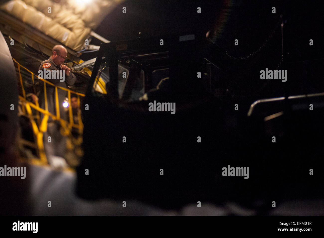 A U.S. Air Force Airman guides a 60K aircraft cargo loader while ...