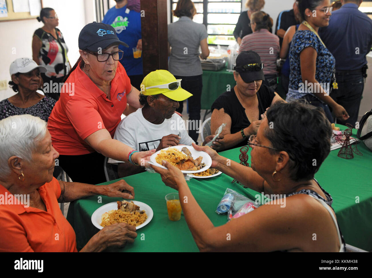 SAN JUAN, Puerto Rico – Aileen Lopez hands out plates filled with ...