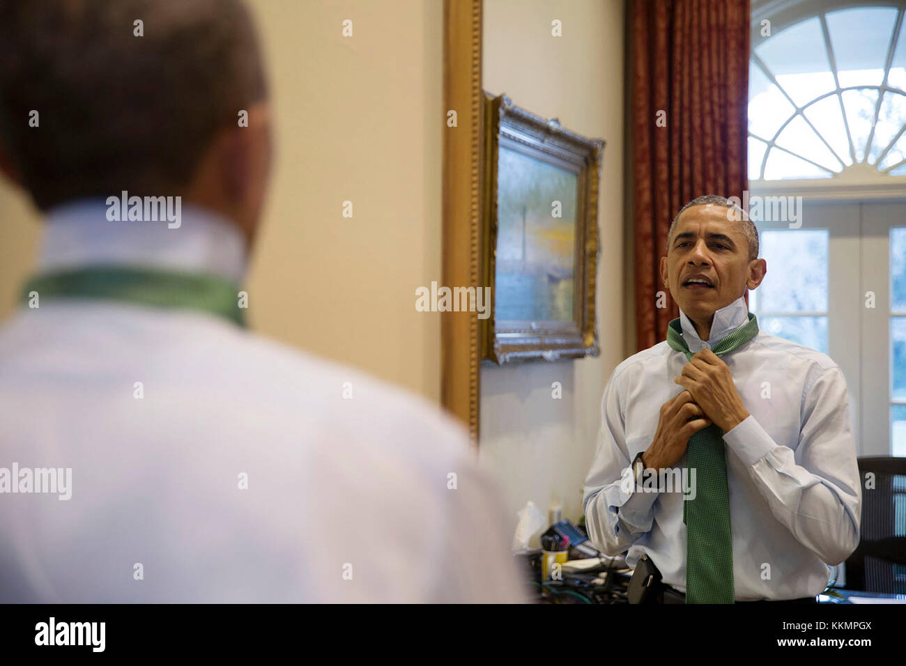 President Barack Obama puts on a green tie in observance of St. Patrick ...