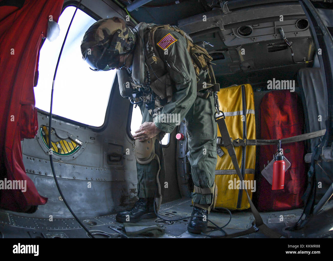 Corpsman 2nd Class Curt Hansen puts on knee pads before a search and ...