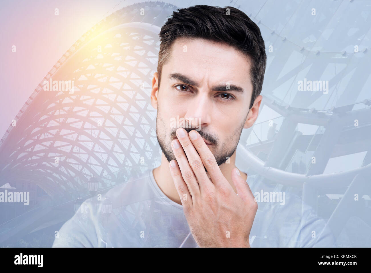 Handsome model covering his mouth Stock Photo - Alamy