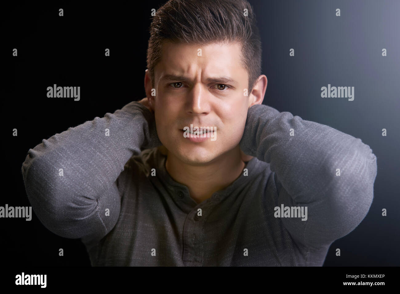 Portrait of angry young white man with hands behind his neck Stock ...