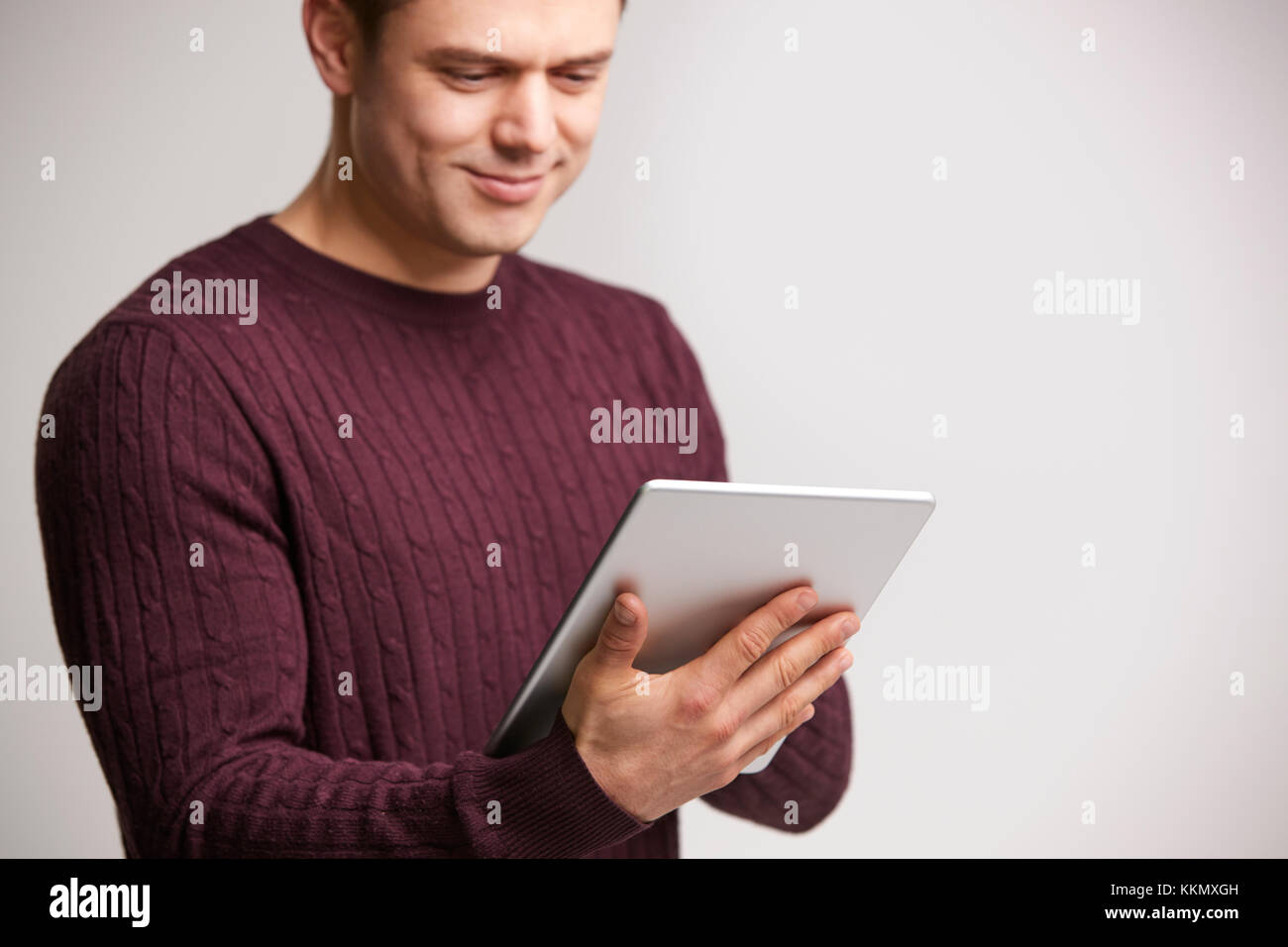 Smiling young white man using a tablet computer Stock Photo - Alamy
