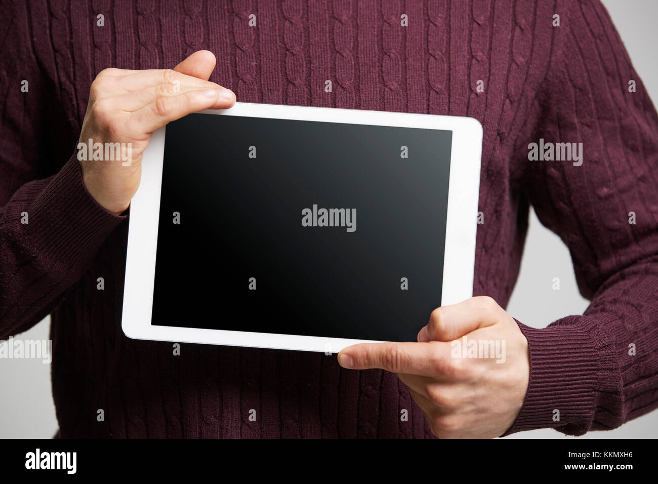 Young man holds a tablet computer showing its screen, mid section Stock ...