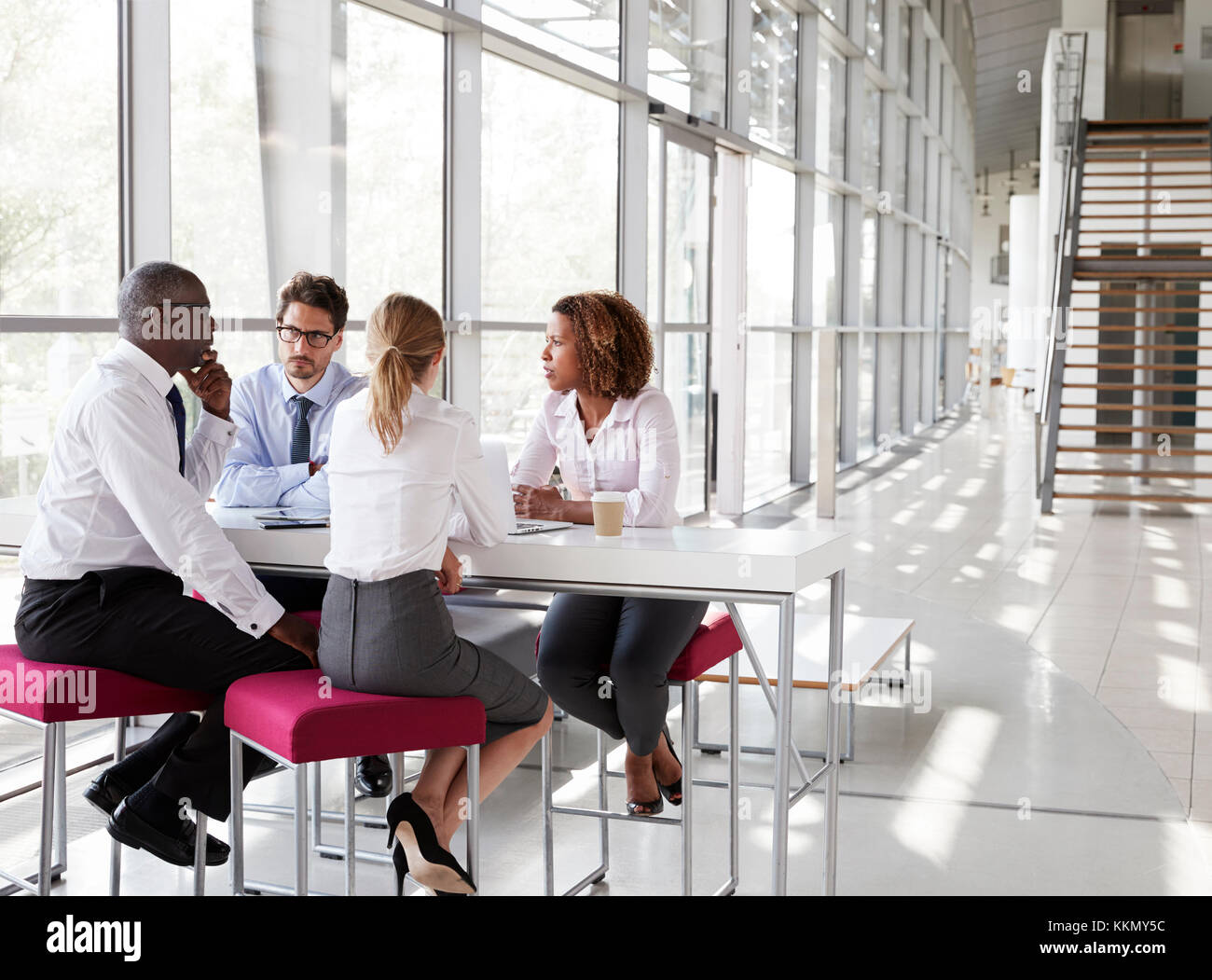 Young business people talking in modern lobby, full length Stock Photo ...