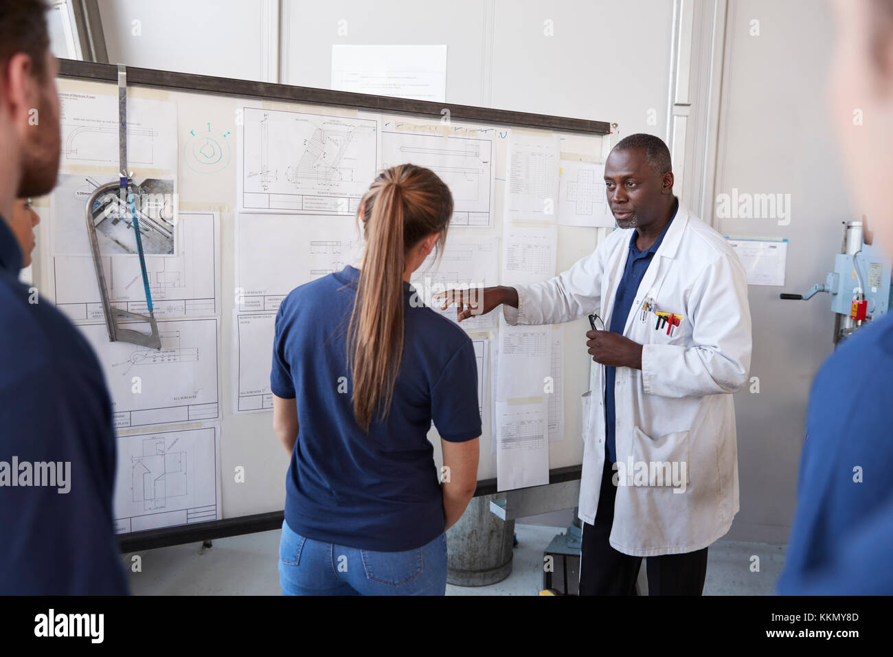 Engineer with apprentice at white board in front of group Stock Photo ...