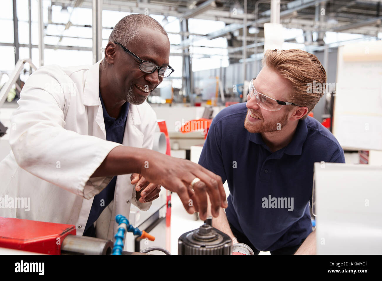 Engineer advising a male apprentice in a factory, close up Stock Photo ...