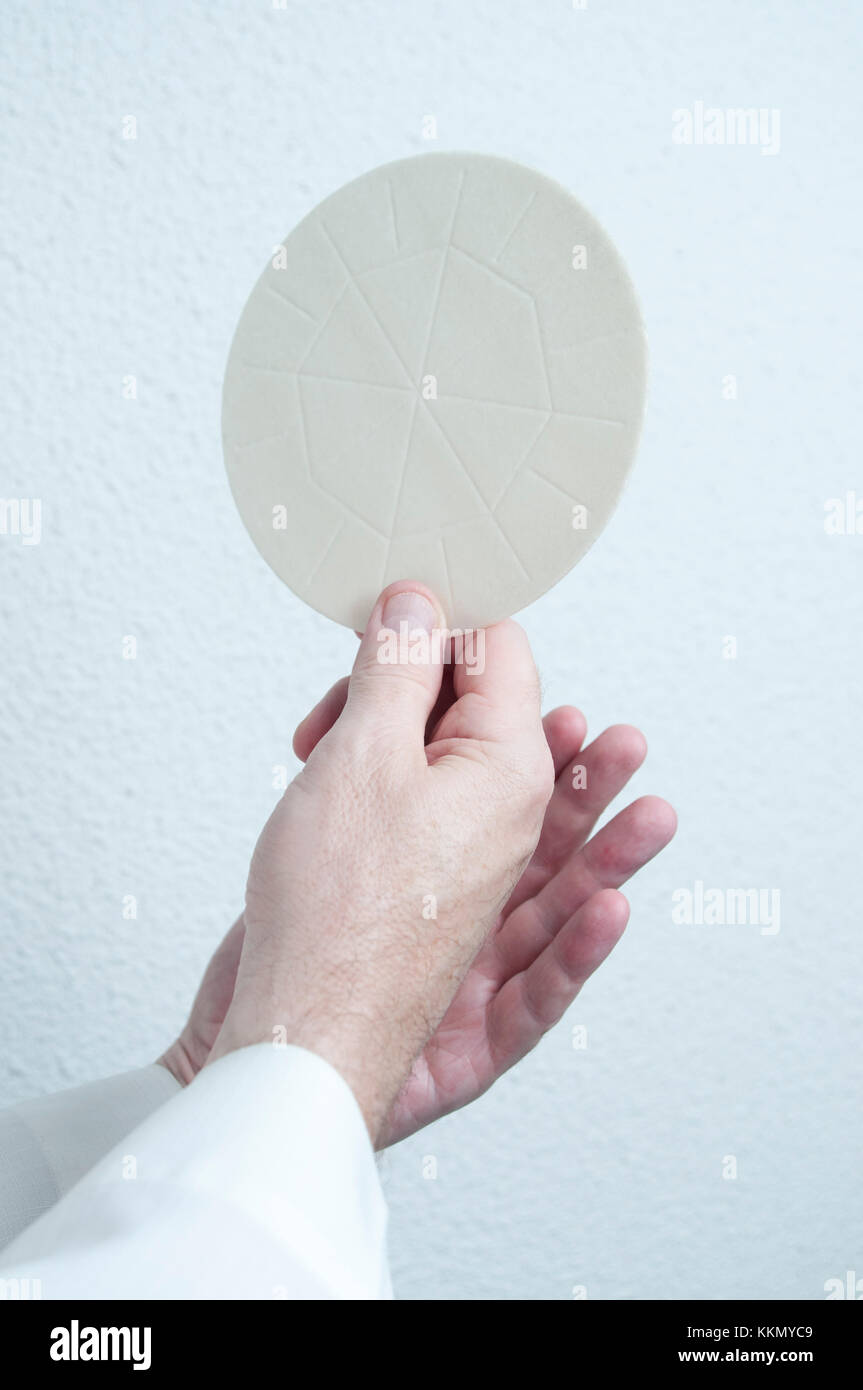 Hands holding eucharist in church hi-res stock photography and images ...