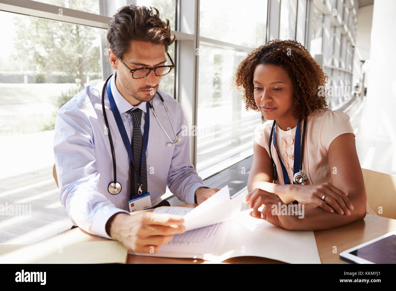 Male and female senior doctors reading patient notes Stock Photo - Alamy