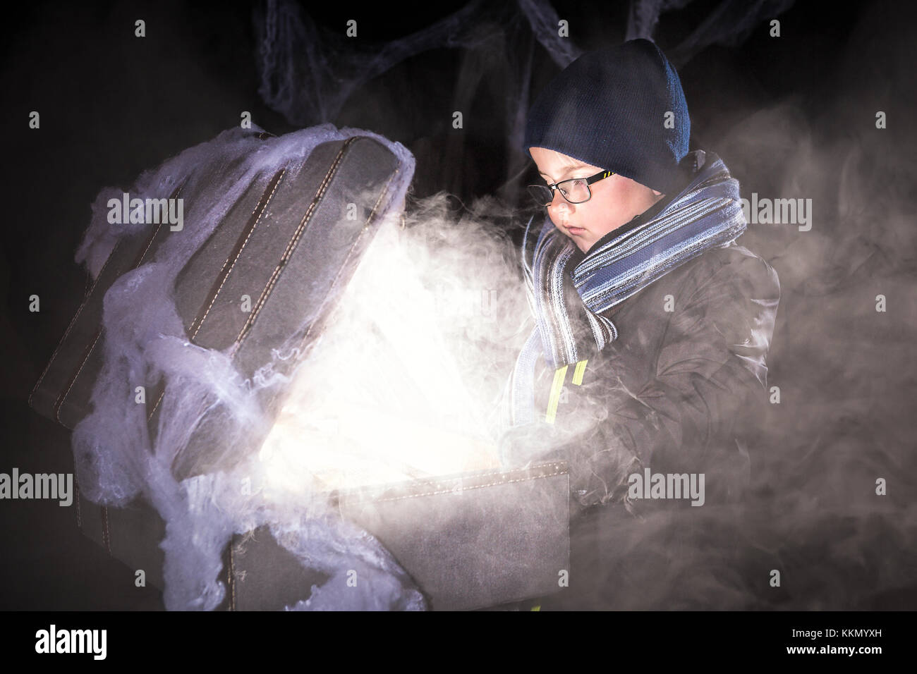 A boy opening an old cobweb covered chest in search of treasure Stock ...