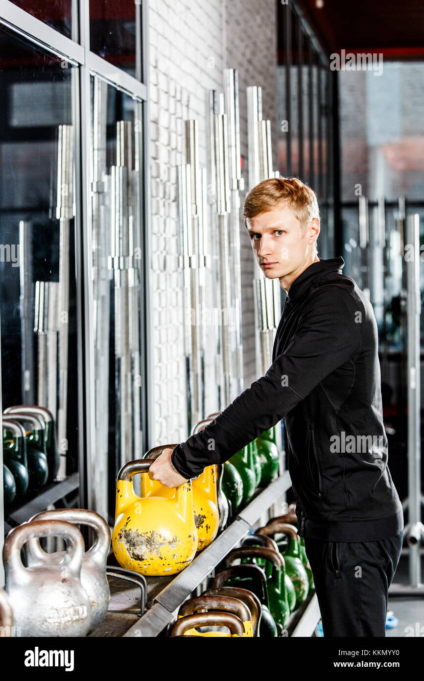 guy removes yellow weights after training in the gym on the window ...