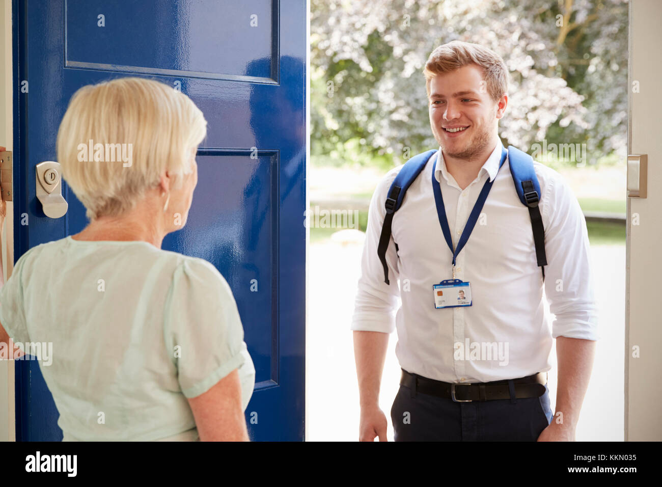 Senior woman greeting male care worker making home visit Stock Photo ...