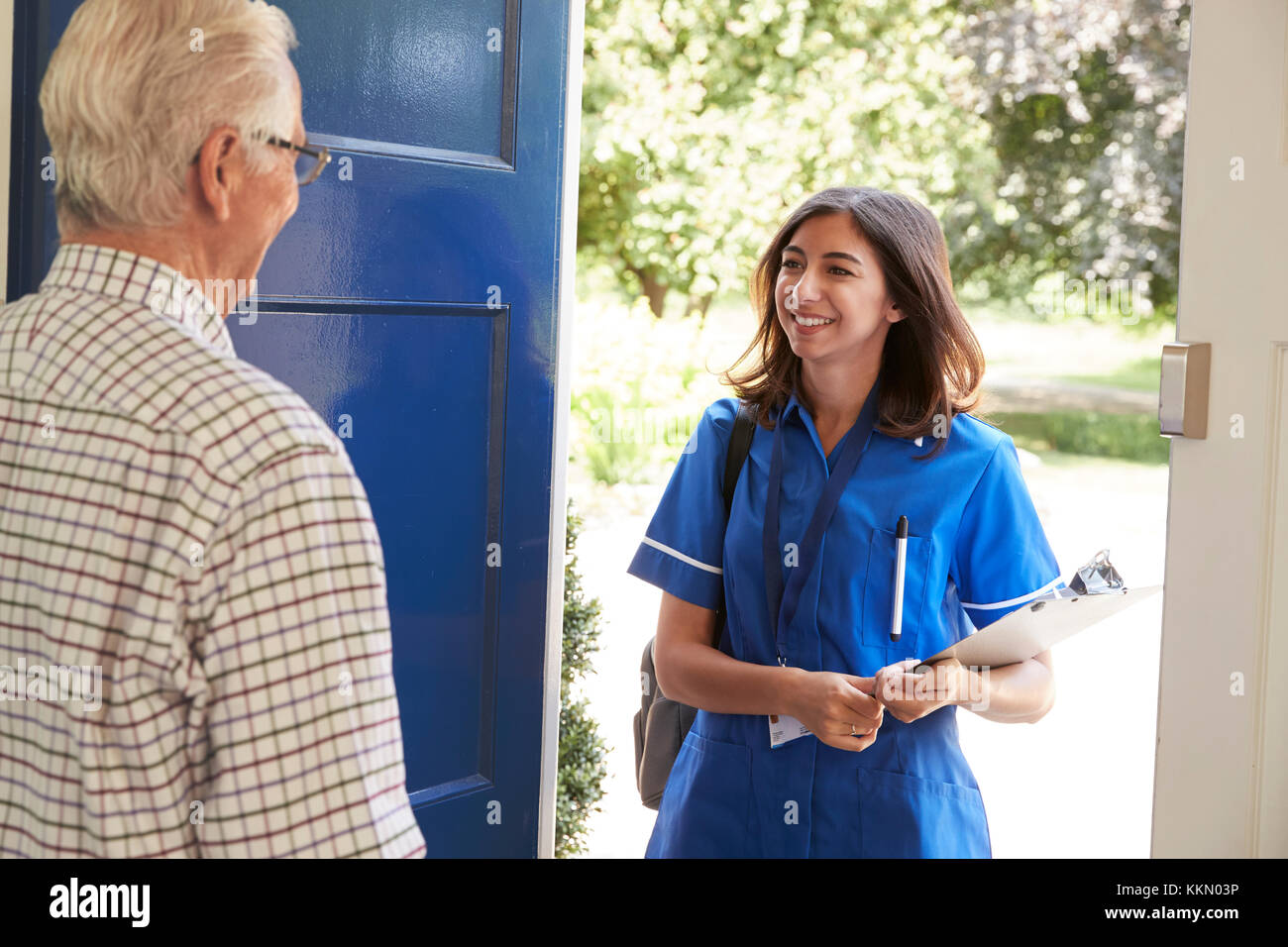 Senior man greeting female nurse making home visit Stock Photo - Alamy