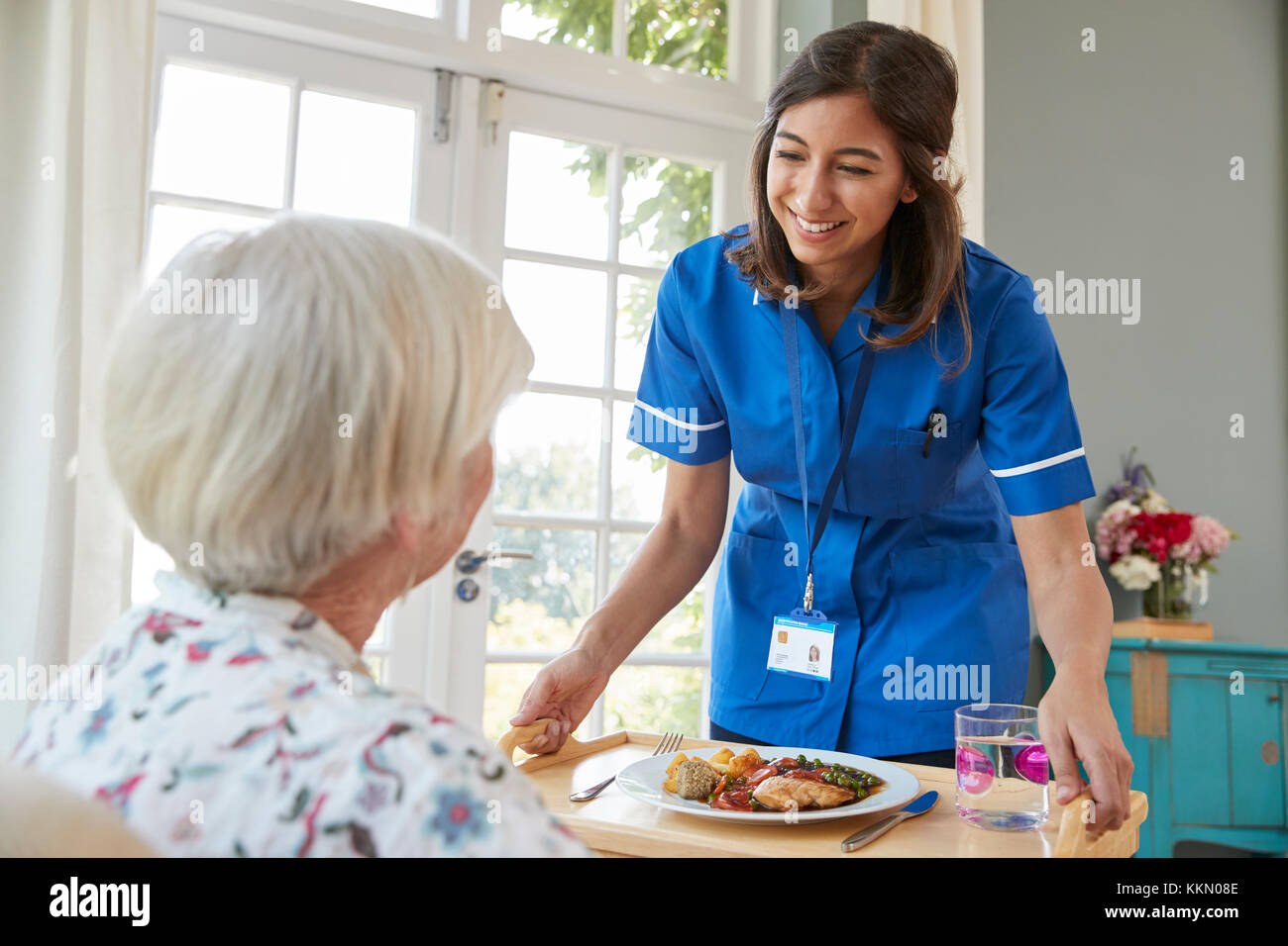 Care nurse serving dinner to a senior woman at home Stock Photo - Alamy