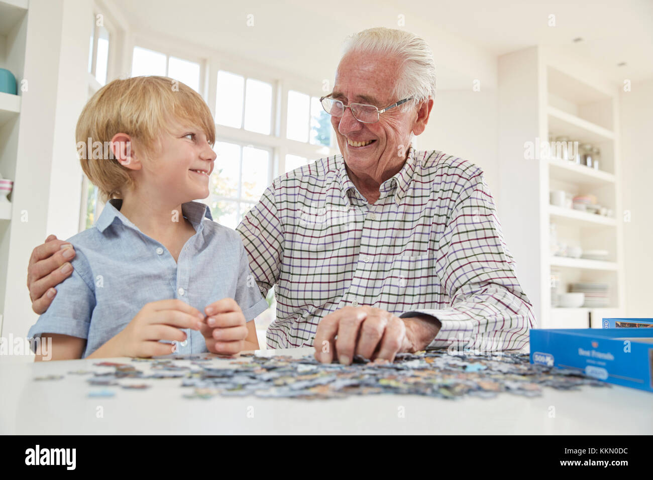 Senior man and grandson doing a jigsaw puzzle at home Stock Photo - Alamy