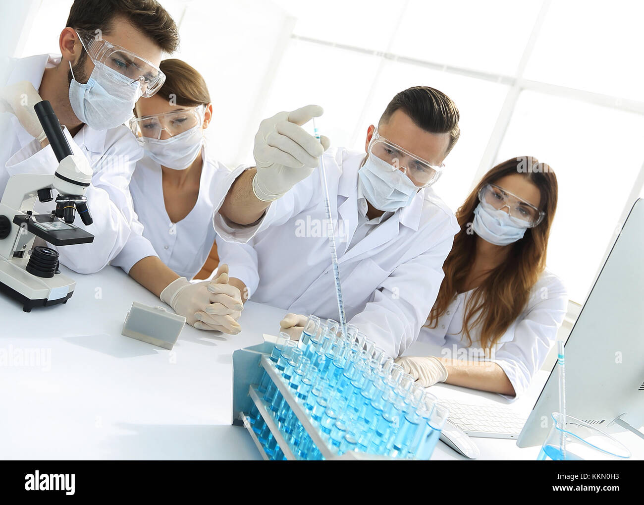 medical doctors are working with test tubes and microscope at the lab ...