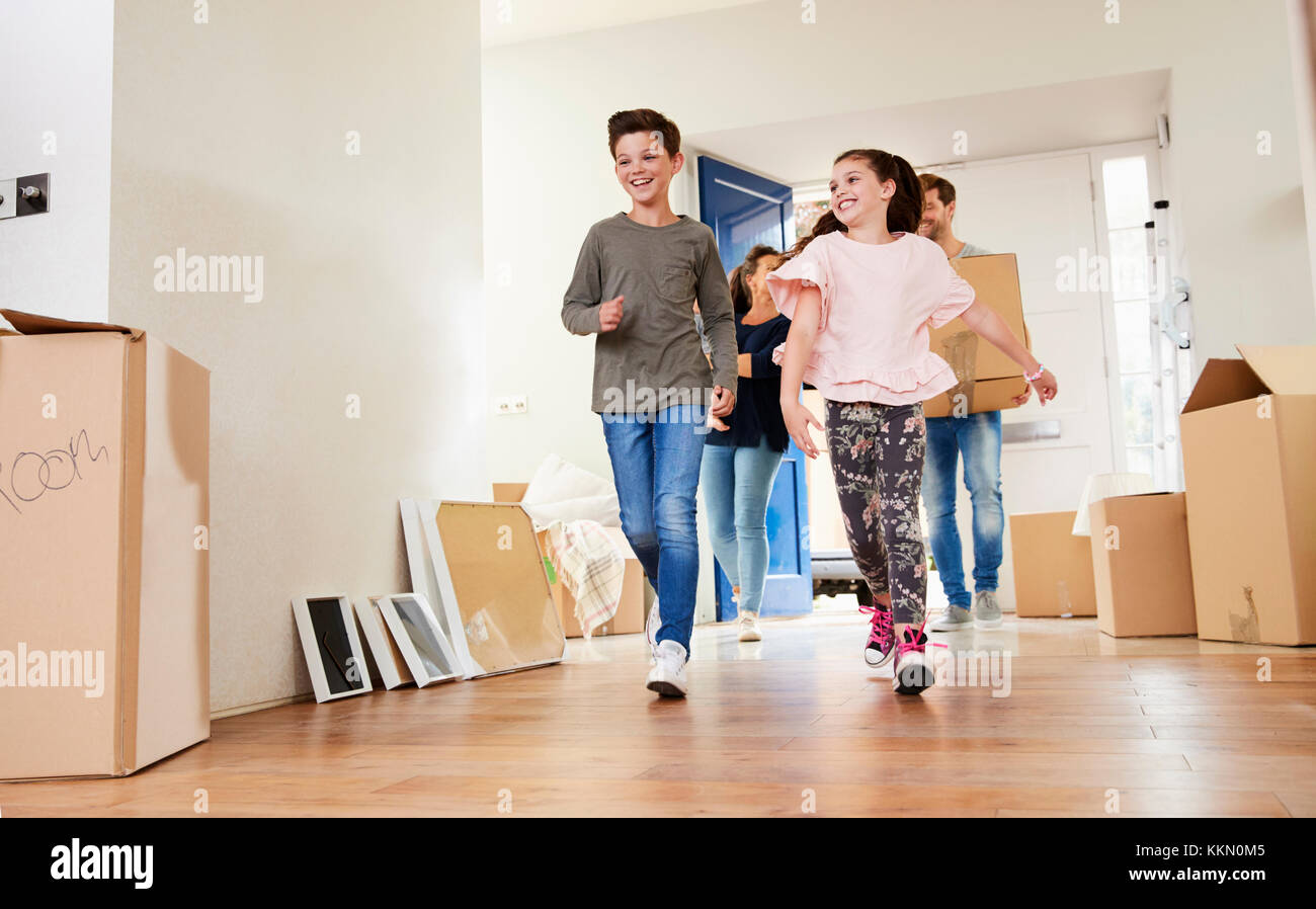 Family Carrying Boxes Into New Home On Moving Day Stock Photo - Alamy