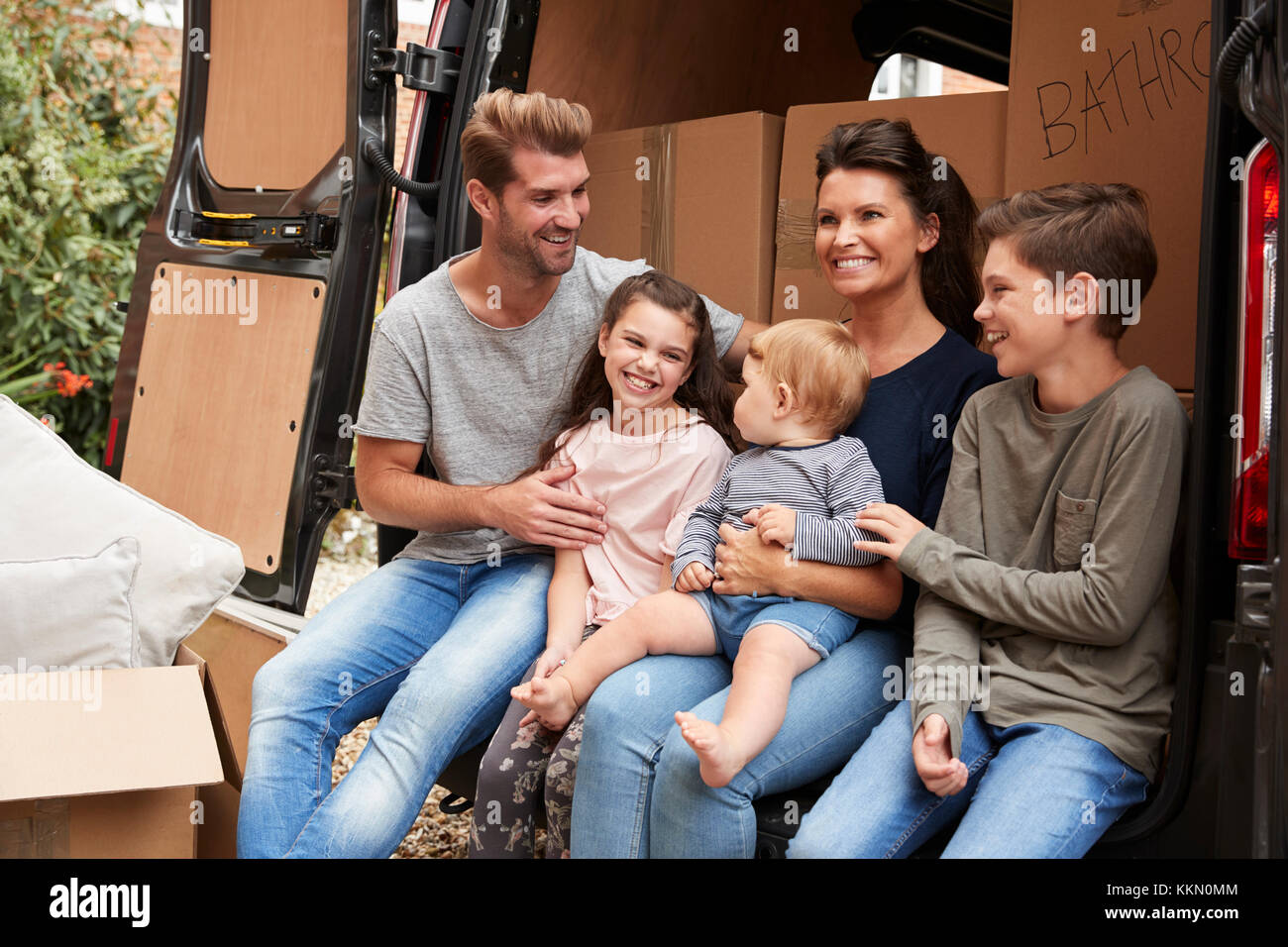 Family Sitting In Back Of Removal Truck On Moving Day Stock Photo - Alamy