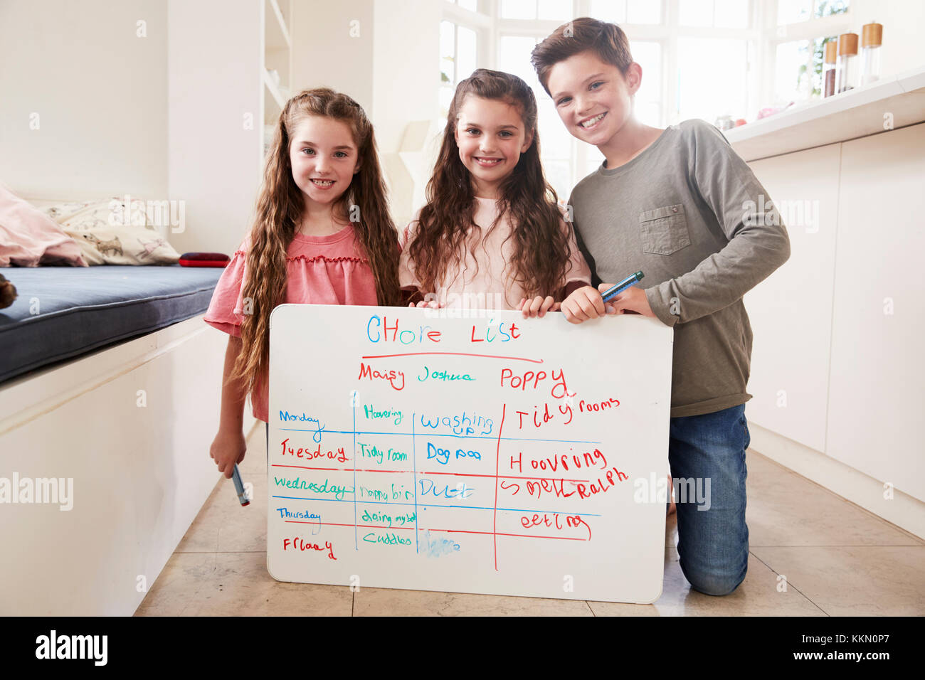 Portrait Of Children Making List Of Chores On Whiteboard At Home Stock ...