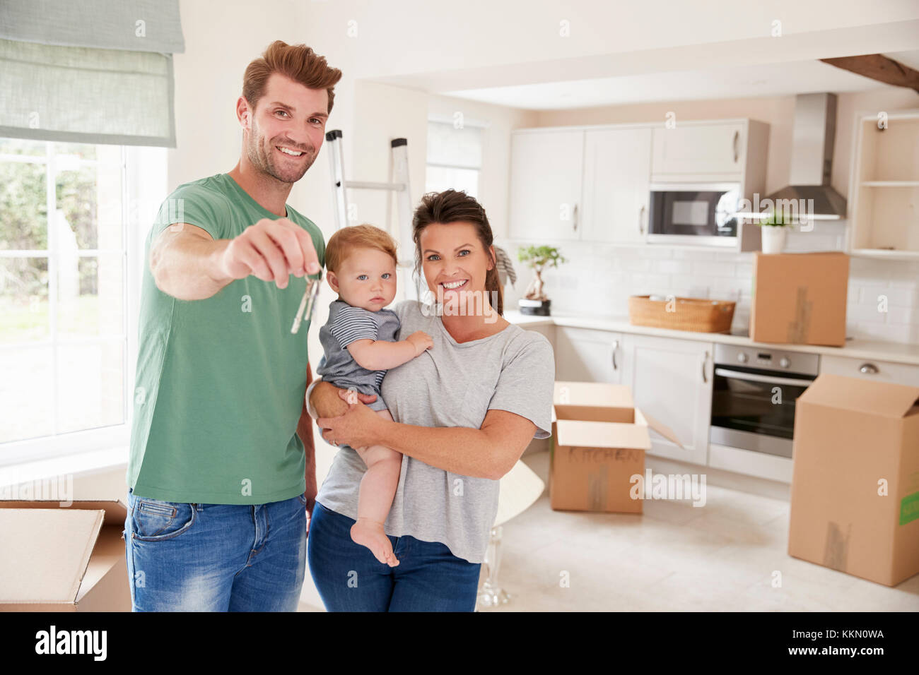 Portrait Of Family With Baby Holding Keys On Moving In Day Stock Photo ...