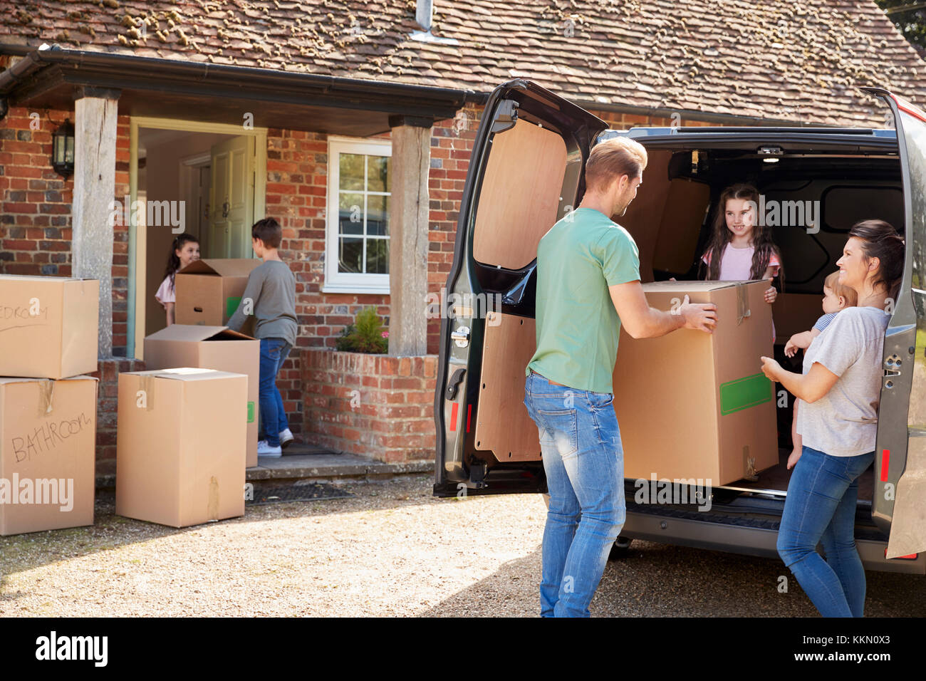 Family Unloading Boxes From Removal Truck On Moving Day Stock Photo - Alamy