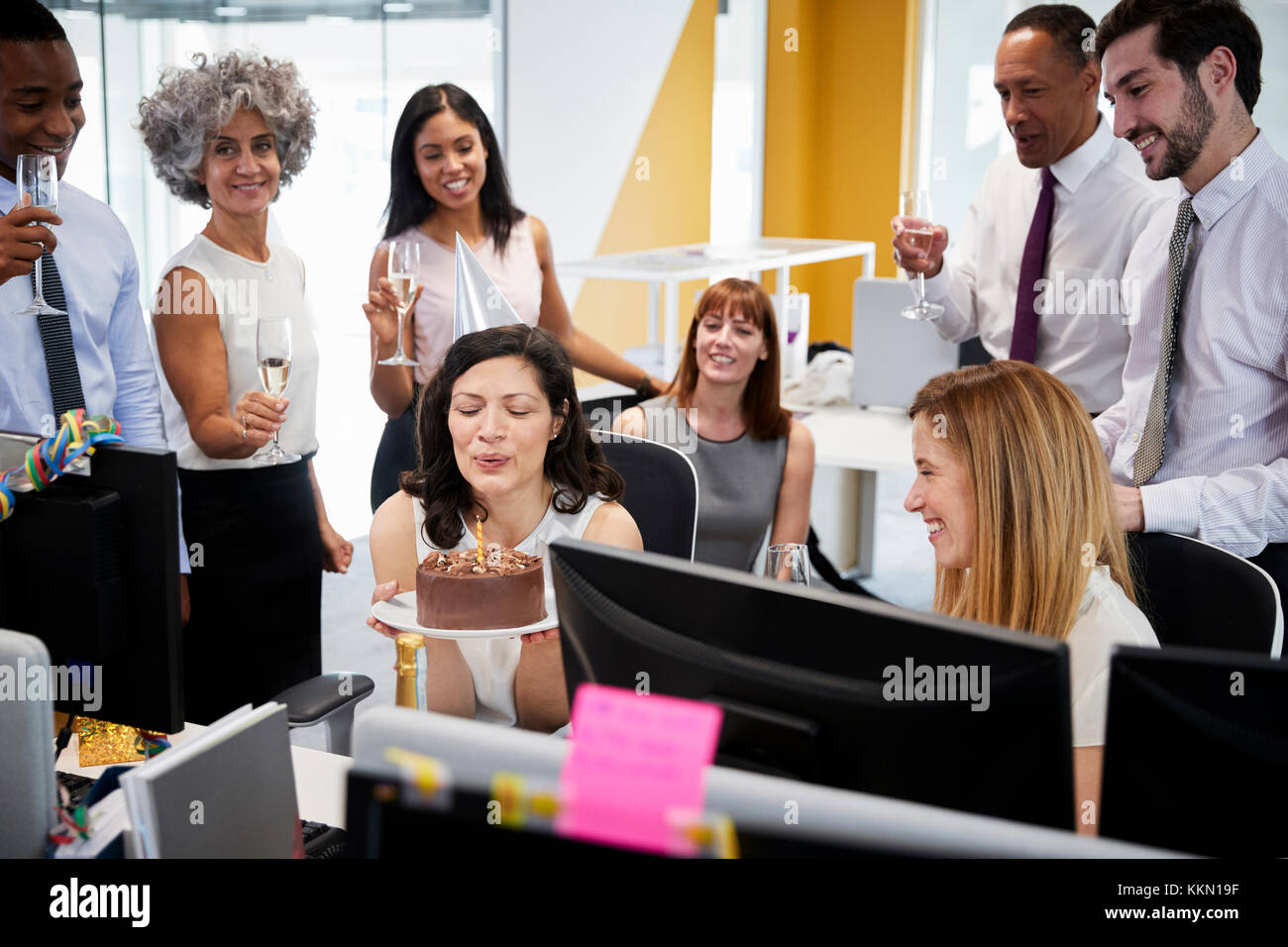 Colleagues gathered at woman’s desk to celebrate a birthday Stock Photo ...