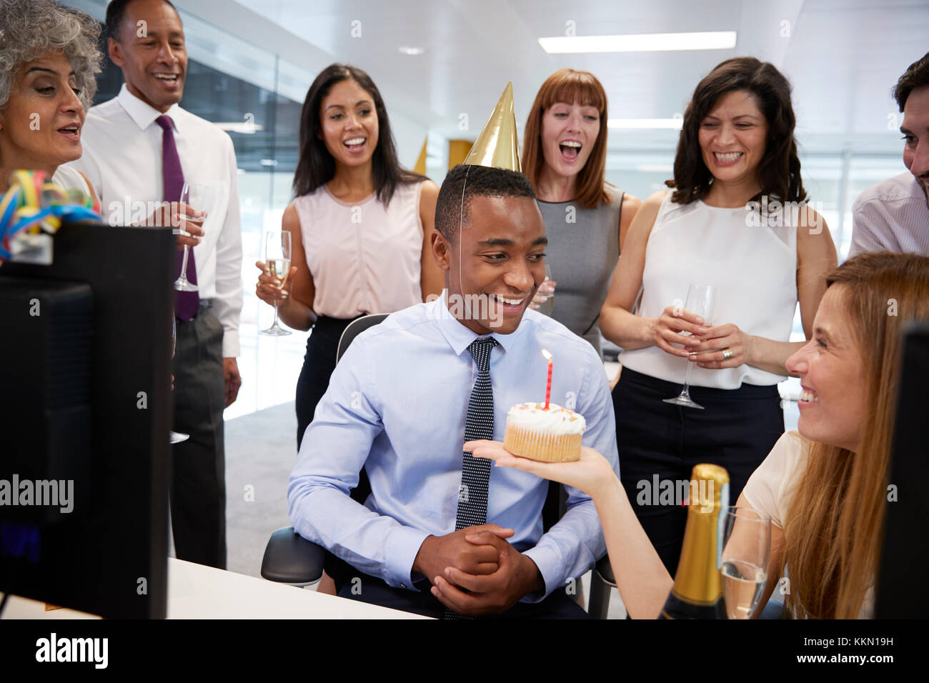 Colleagues gathered at a man’s desk to celebrate a birthday Stock Photo ...