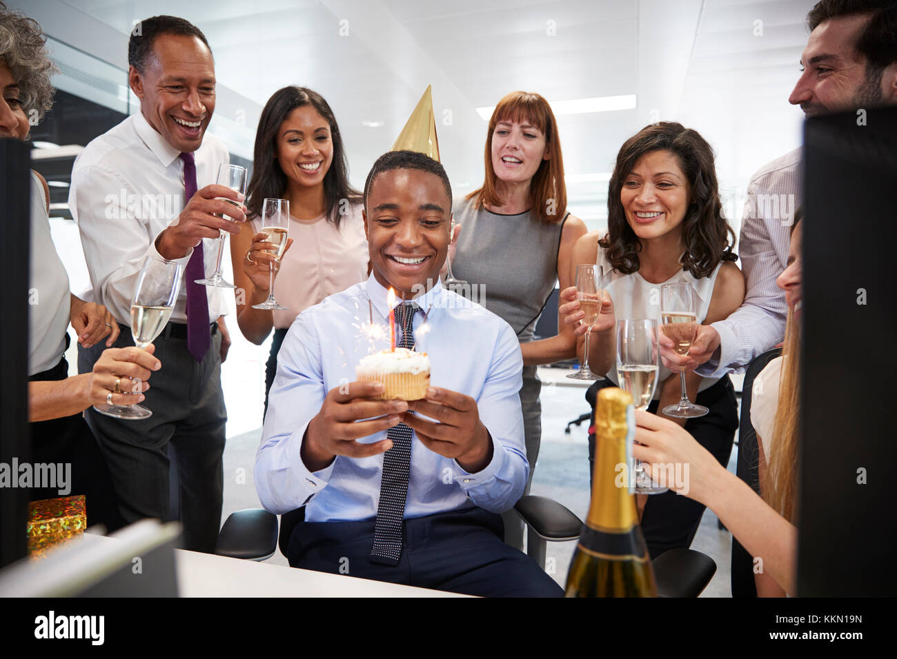 Colleagues gathered at a man’s desk to celebrate a birthday Stock Photo ...