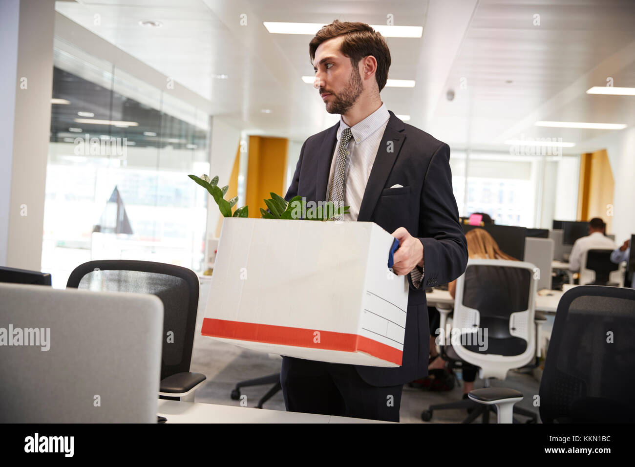 Fired male employee holding box of belongings in an office Stock Photo ...