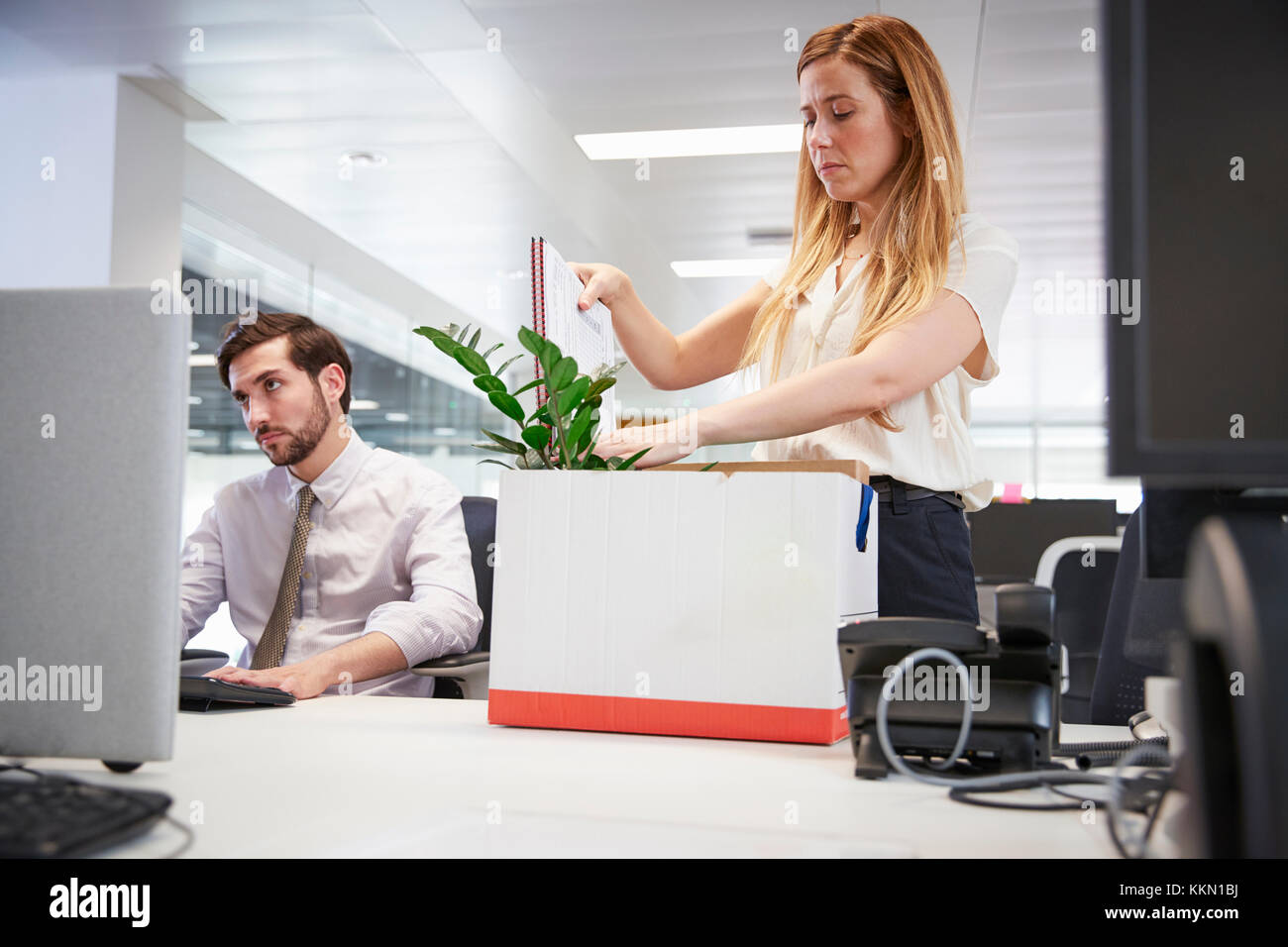 Fired female employee packing box of belongings in an office Stock ...