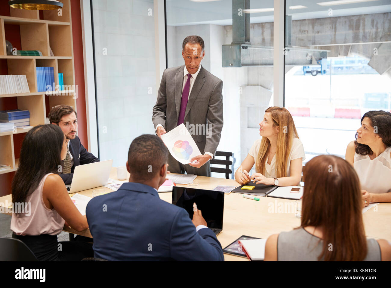 Male boss holding document at a business boardroom meeting Stock Photo ...