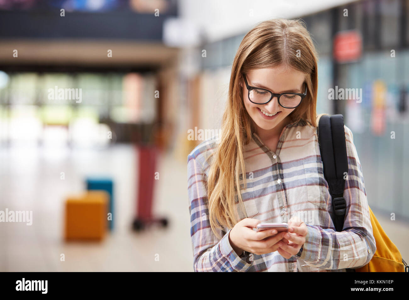 Female College Student Reading Text Message On Mobile Phone Stock Photo ...