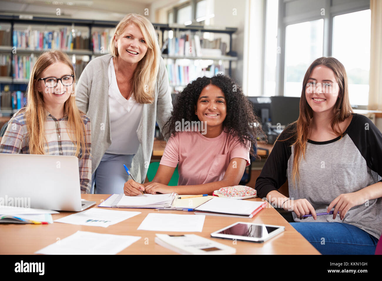 Woman Teacher Working With Female College Students In Library Stock ...