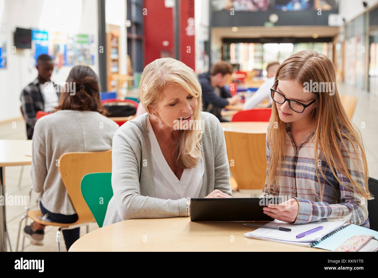 Teacher Talks To Student In Communal Area Of College Campus Stock Photo ...