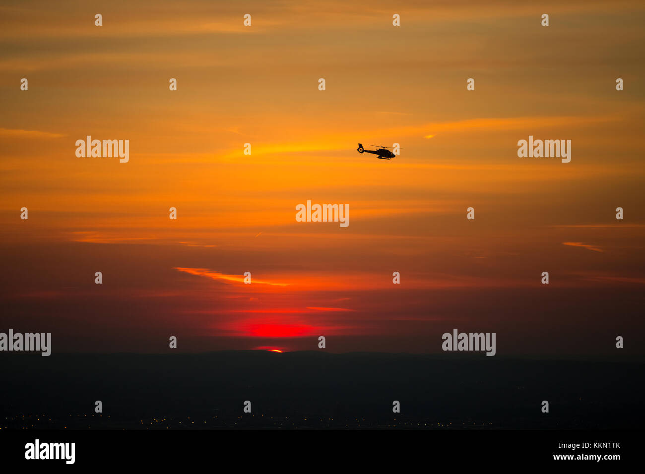Silhouette of a helicopter against sun at dusk Stock Photo - Alamy