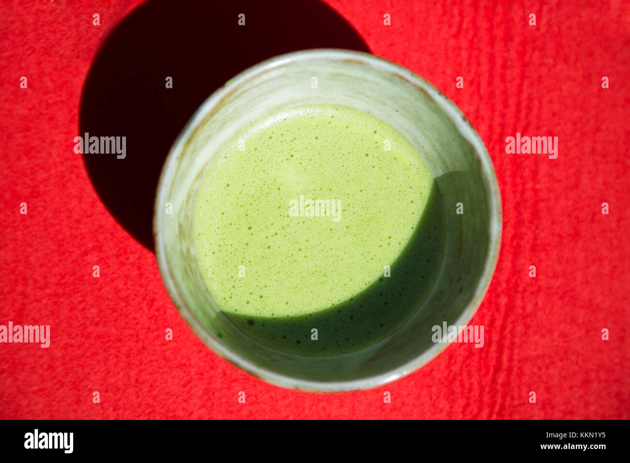 Top view of a cup of green tea over a red background Stock Photo - Alamy