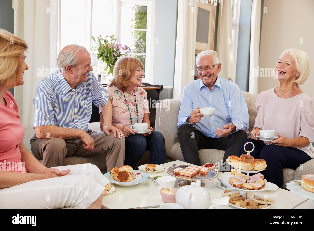 Group Of Senior Friends Enjoying Afternoon Tea At Home Together Stock ...