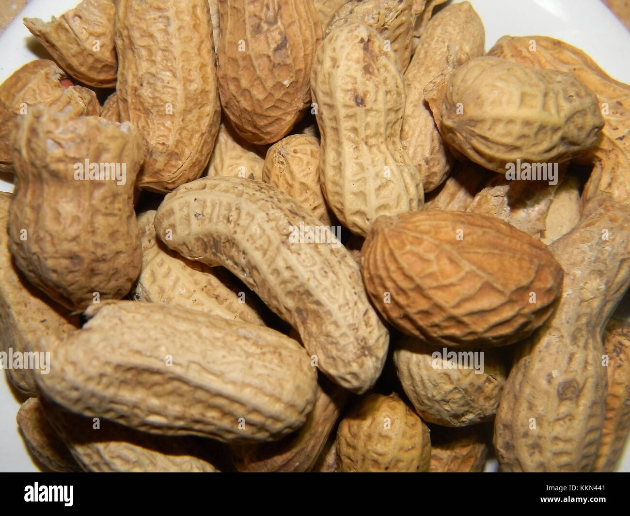 variety of salty peanuts with and without peel on white background ...